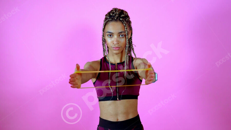Black woman with braids hairstyle doing exercise using resistance band ...